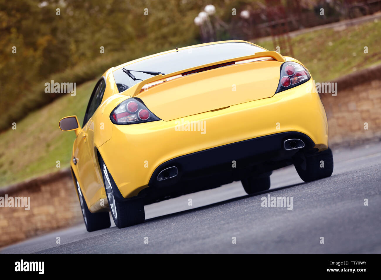 New yellow car on the road Stock Photo - Alamy