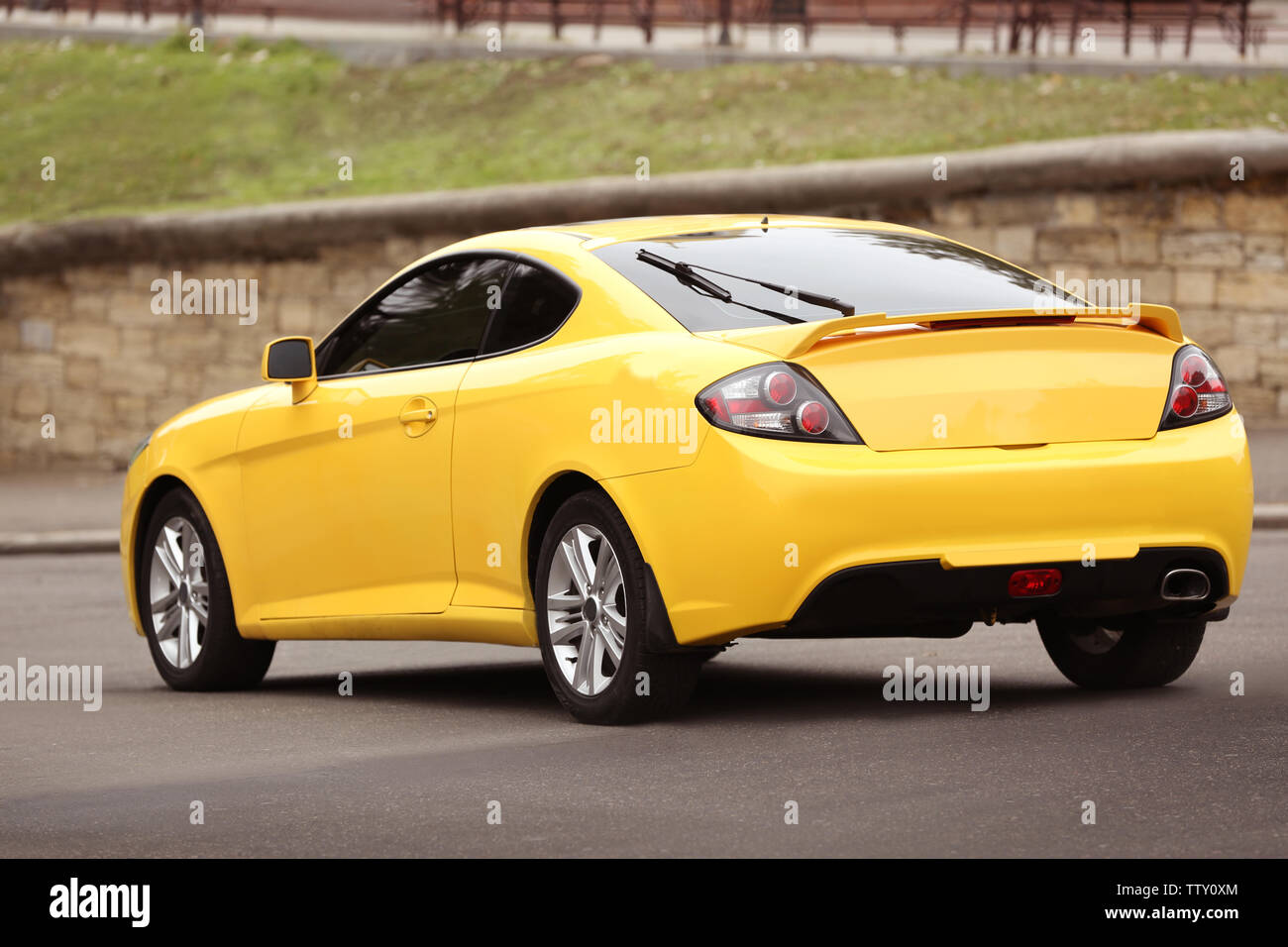 New yellow car on the road Stock Photo - Alamy