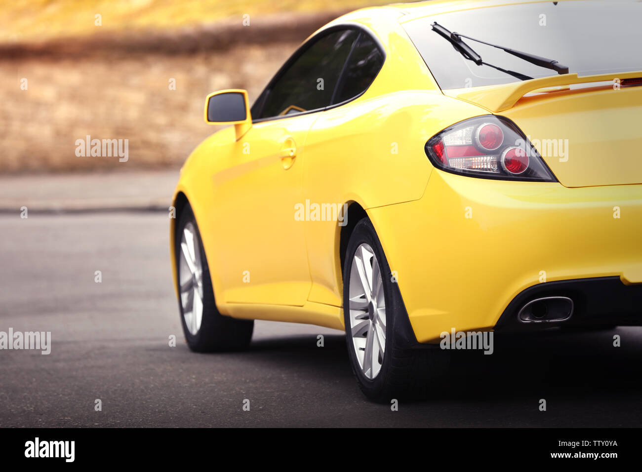 New yellow car on the road Stock Photo - Alamy
