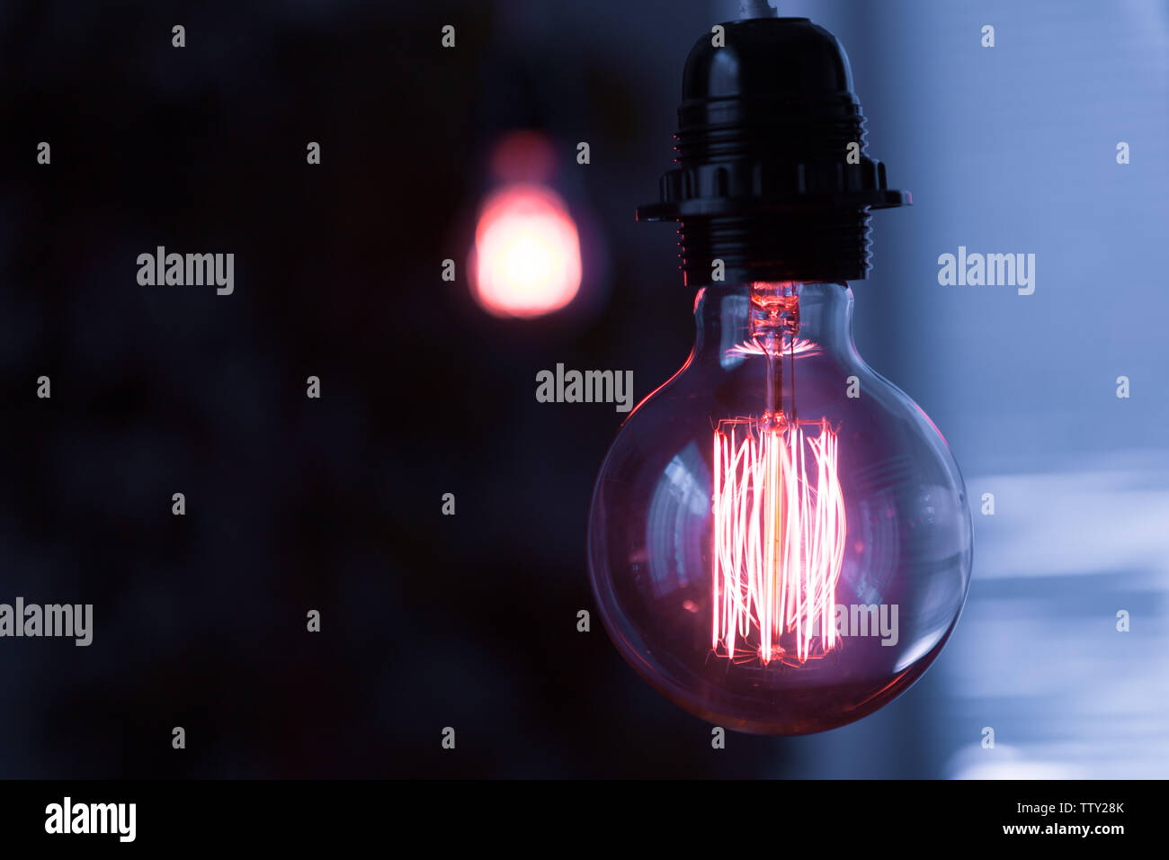 A classic Edison light bulb on dark background with space for text ...
