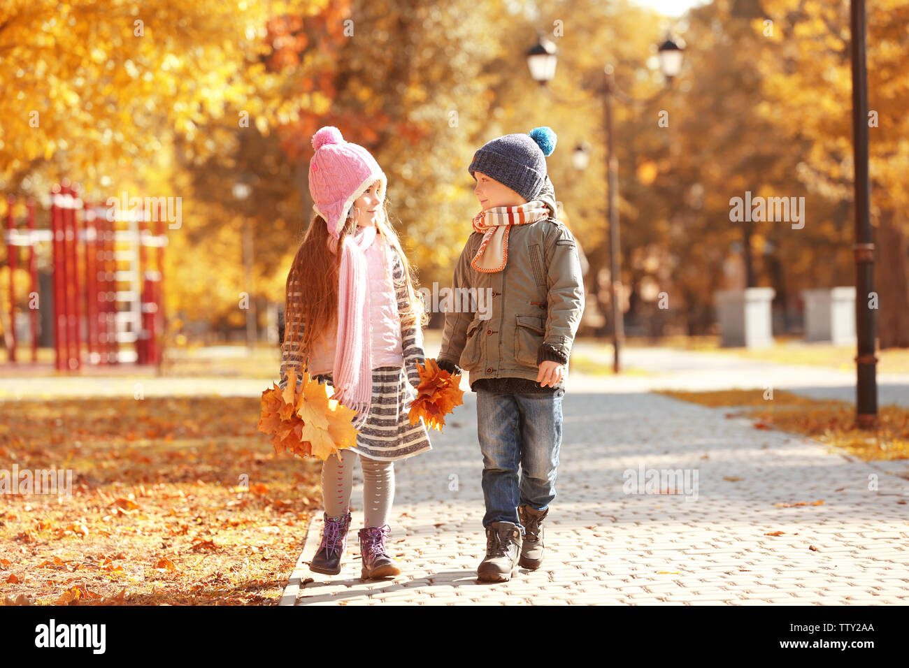 Happy children walking in park with leaves in hands Stock Photo - Alamy