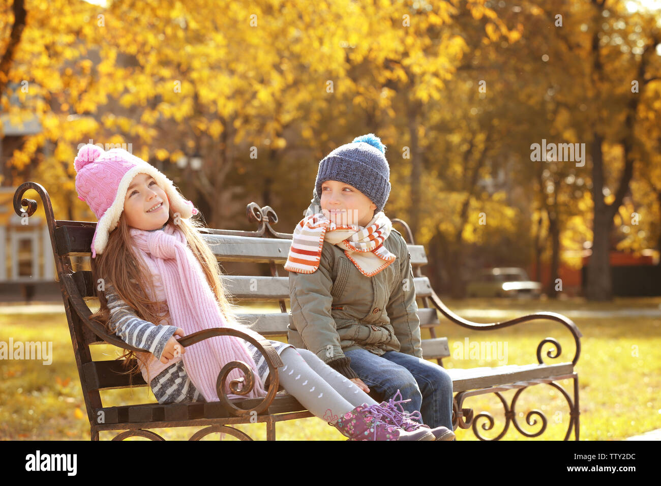 Happy children sitting on bench in park Stock Photo - Alamy