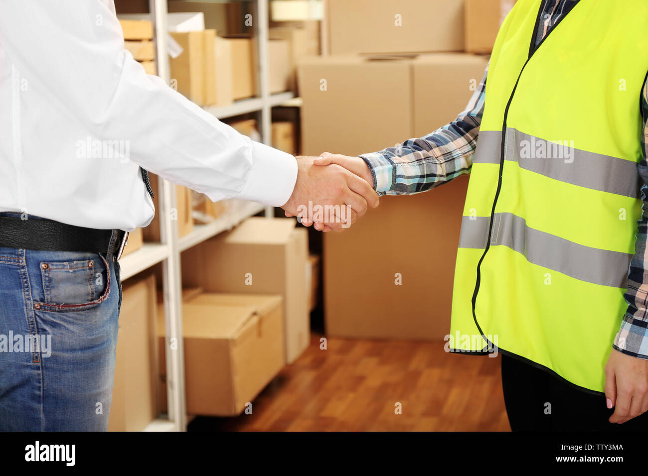 Two business people shaking hands at warehouse Stock Photo - Alamy