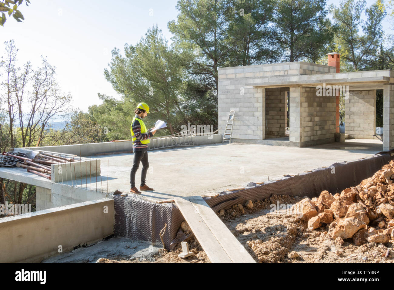 Apprentice craftsman, building trade checking a plan on a construction ...