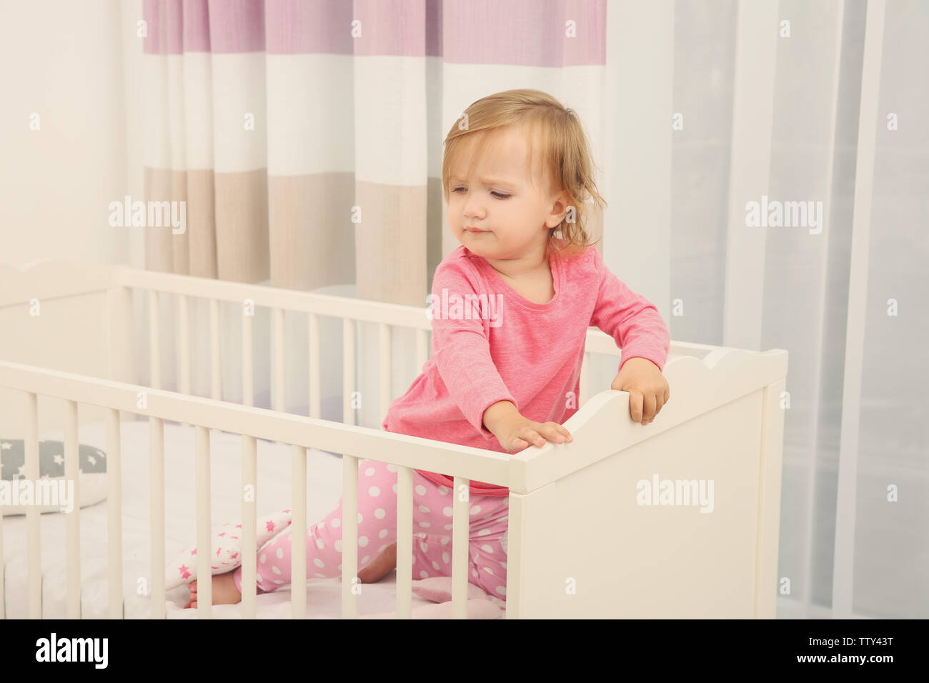 Cute little girl in cradle at baby room Stock Photo - Alamy
