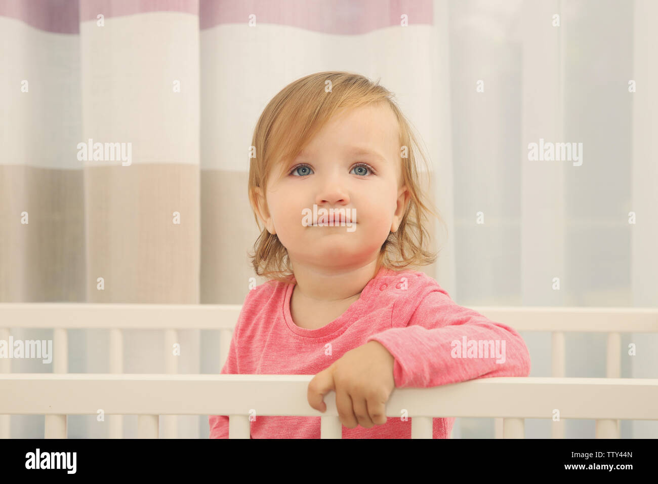 Cute little girl in cradle at baby room Stock Photo - Alamy