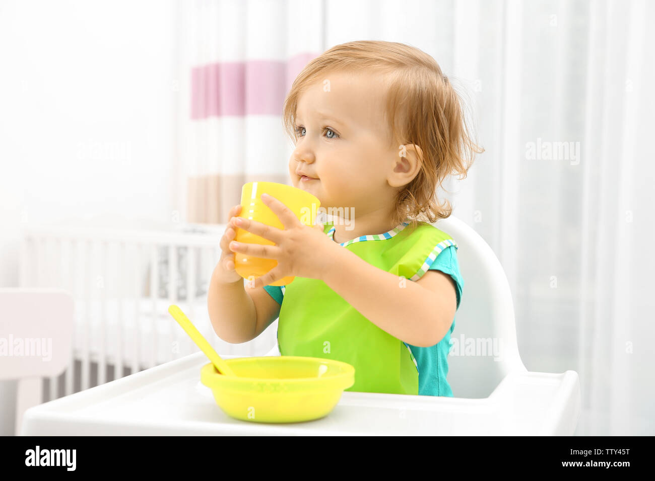 Cute little girl in high chair at baby room Stock Photo - Alamy