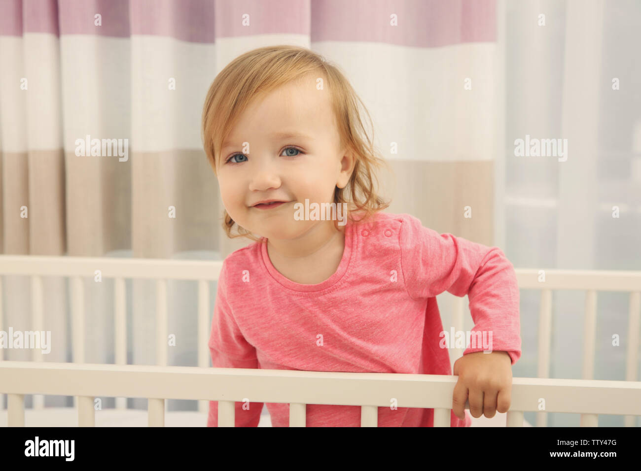 Cute little girl in cradle at baby room Stock Photo - Alamy