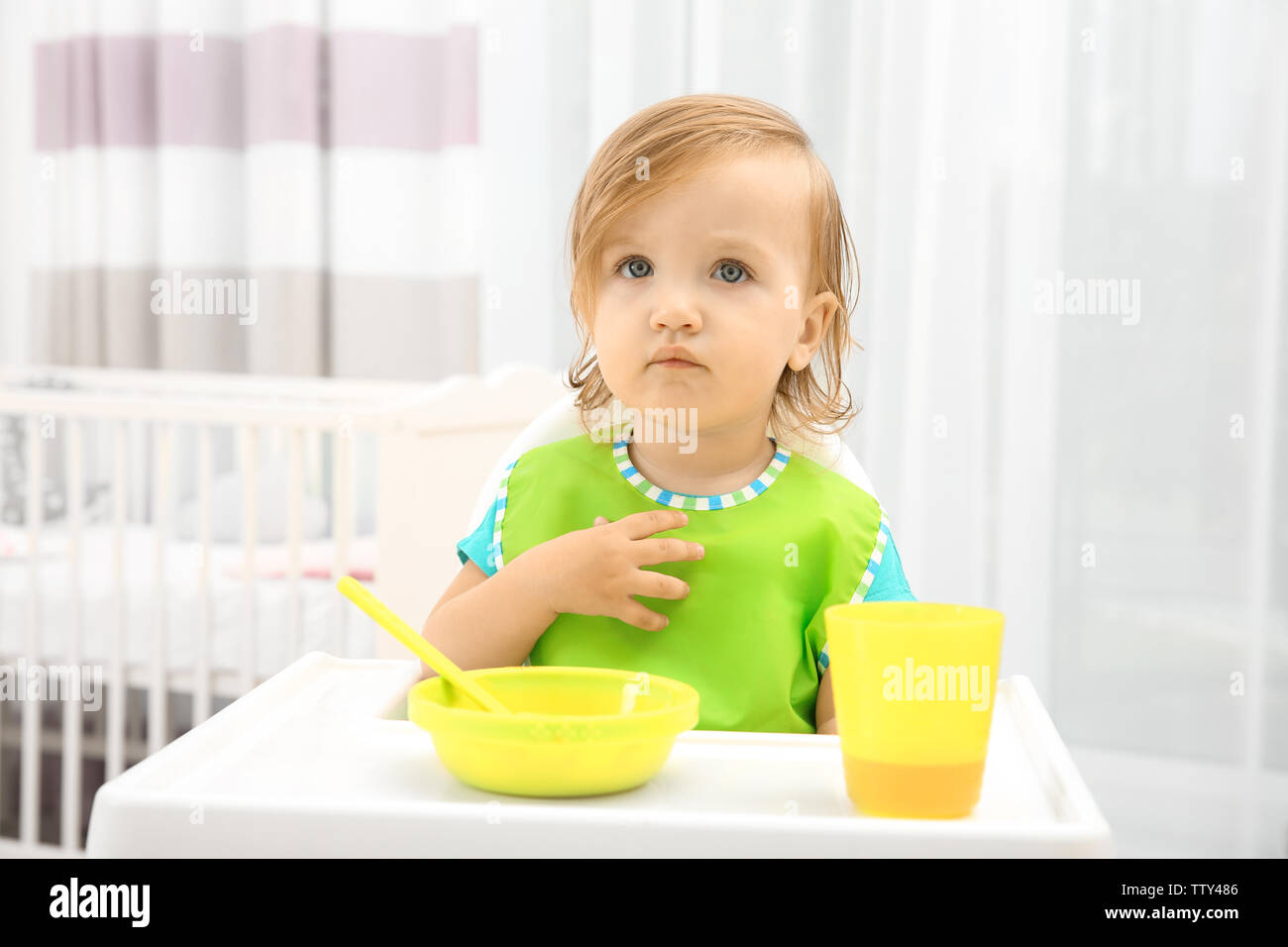 Cute little girl in high chair at baby room Stock Photo - Alamy