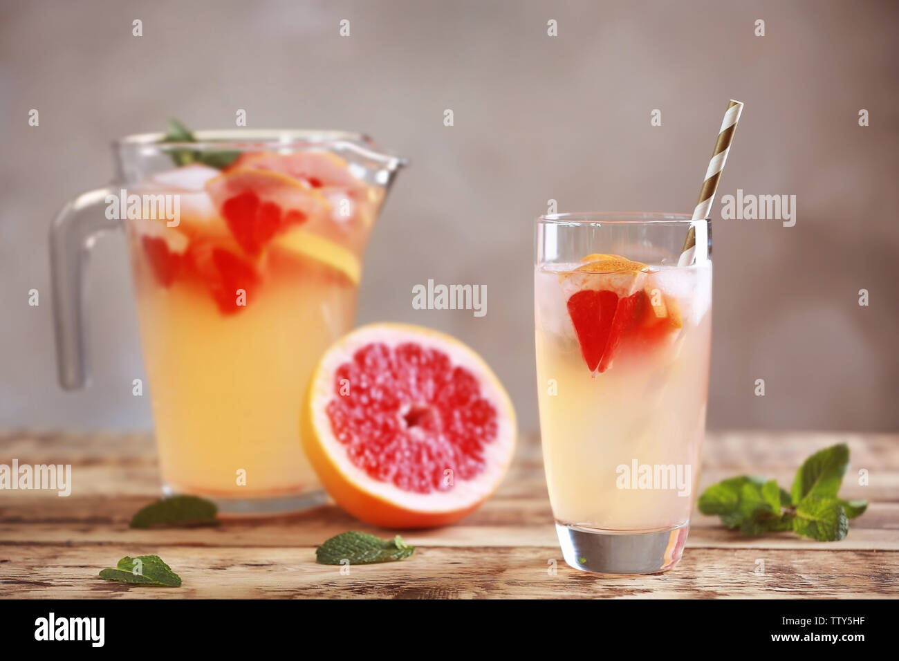 Glass of fresh grapefruit water on grey background Stock Photo - Alamy
