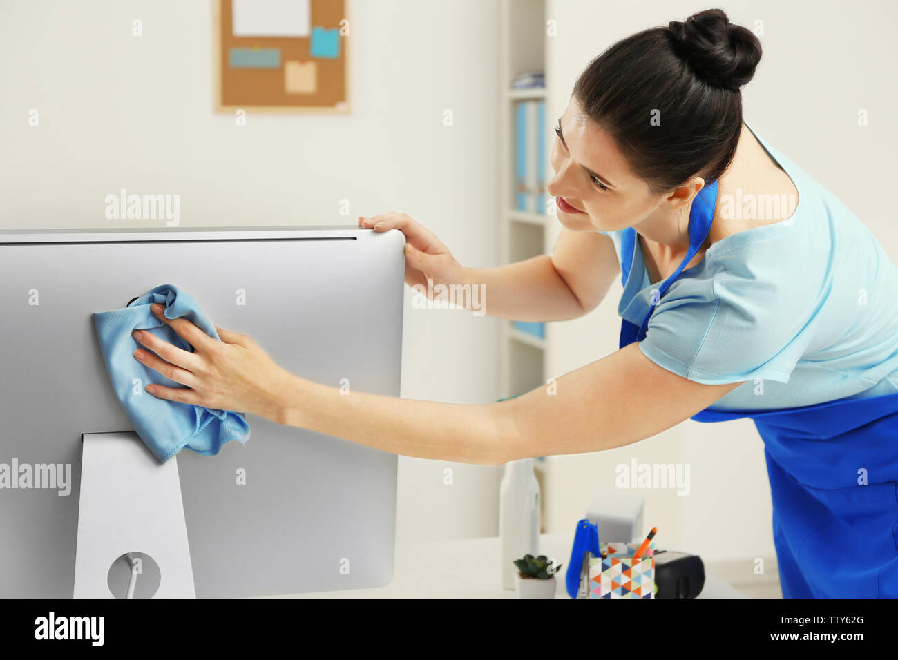 Young woman cleaning computer display Stock Photo - Alamy