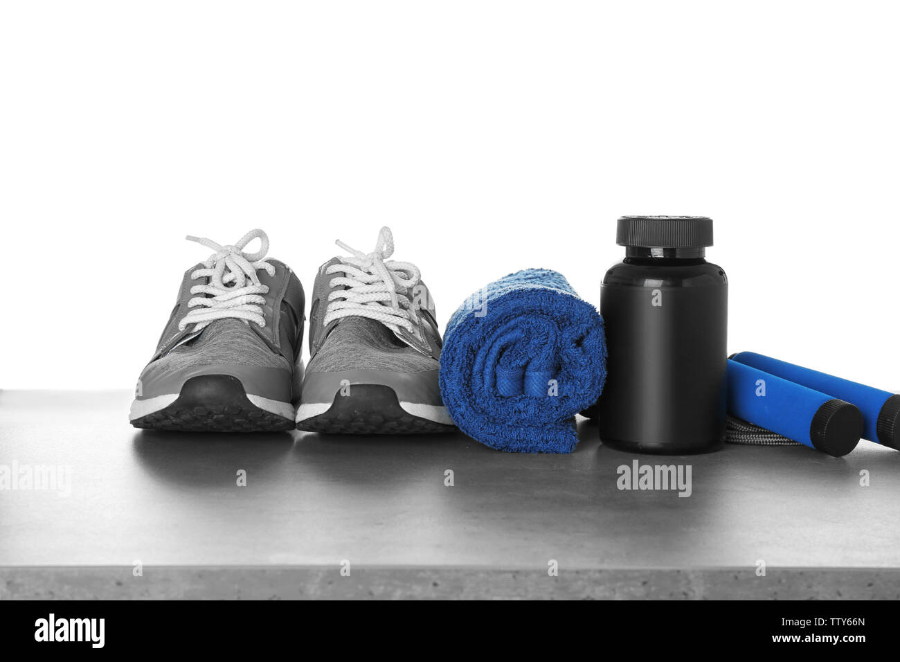 Sports concept. Workout objects on grey table and white background ...