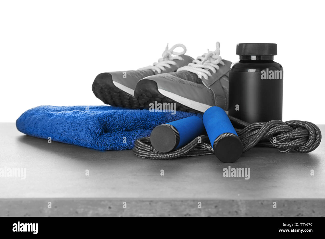 Sports concept. Workout objects on grey table and white background ...