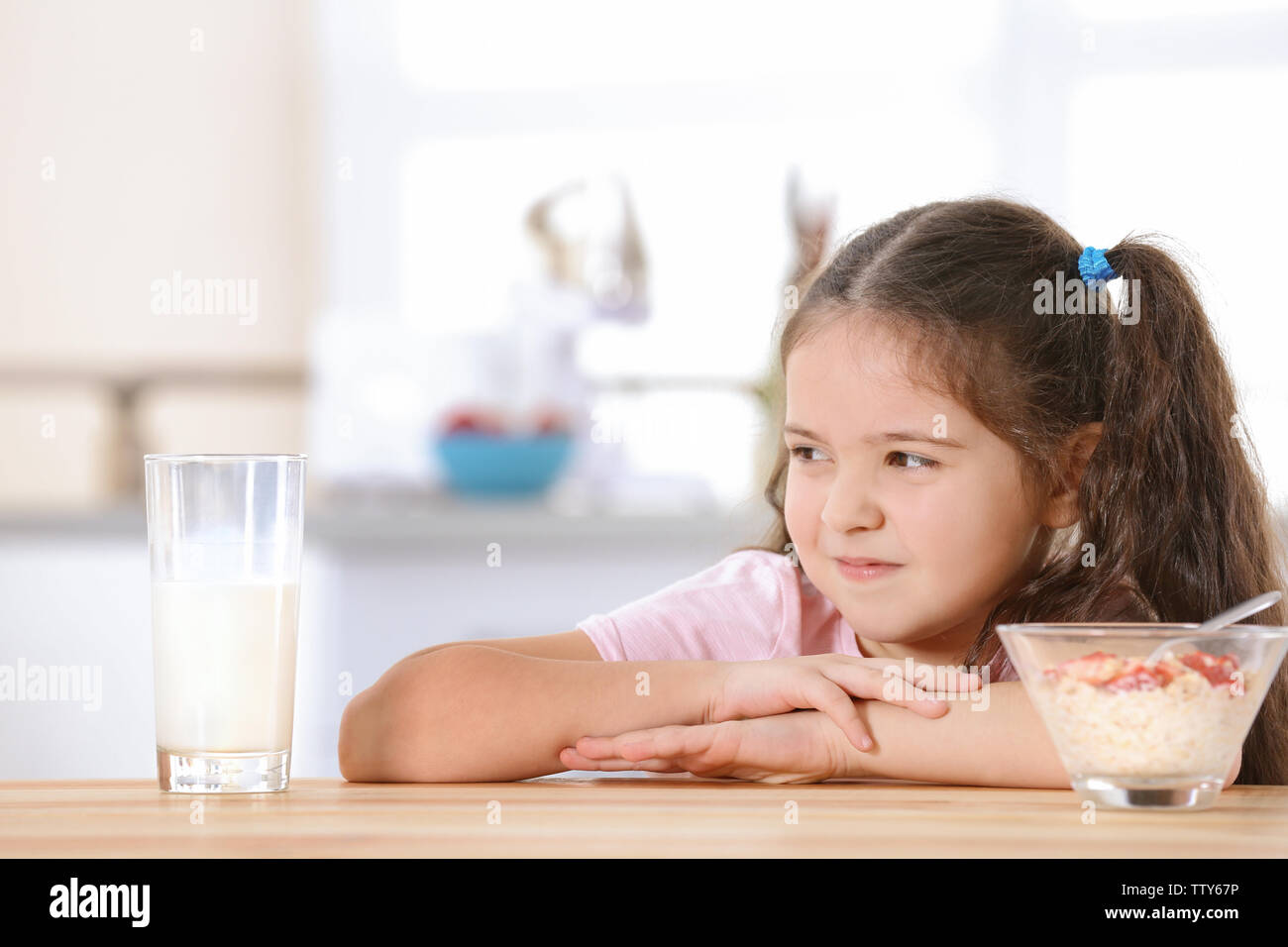 Cute little girl refusing to drink milk Stock Photo - Alamy