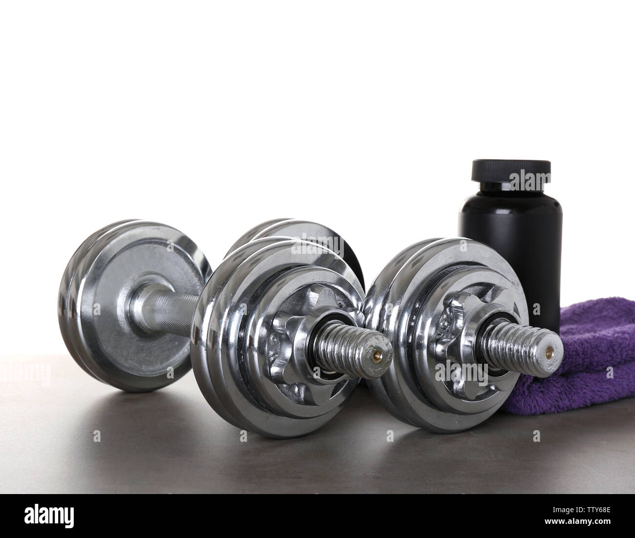 Sports concept. Workout objects on grey table and white background ...