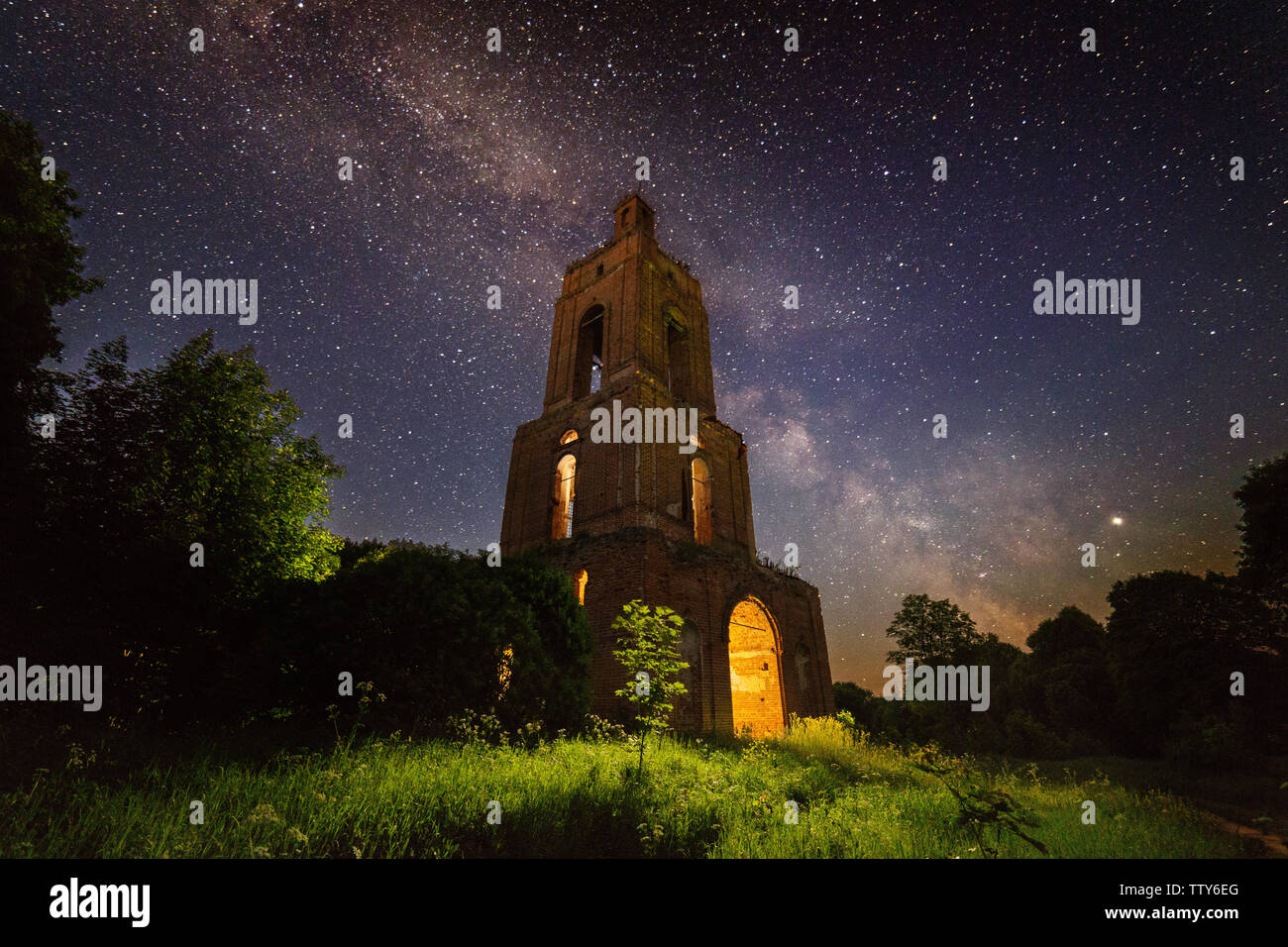 night brick bell tower ruin in forest at starry night with mystical ...