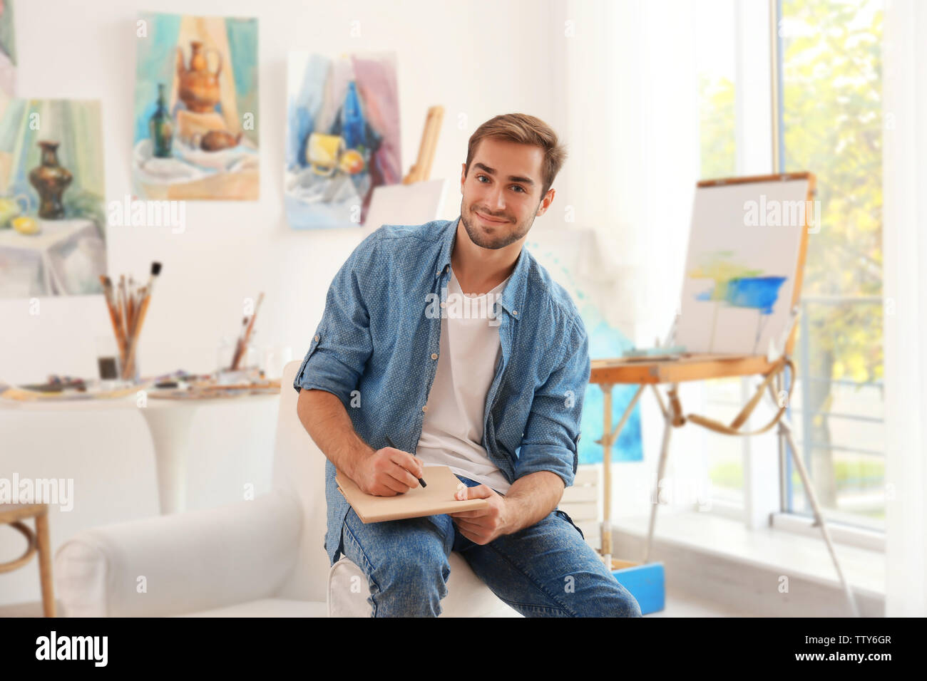 Young male artist drawing sketch in studio Stock Photo - Alamy
