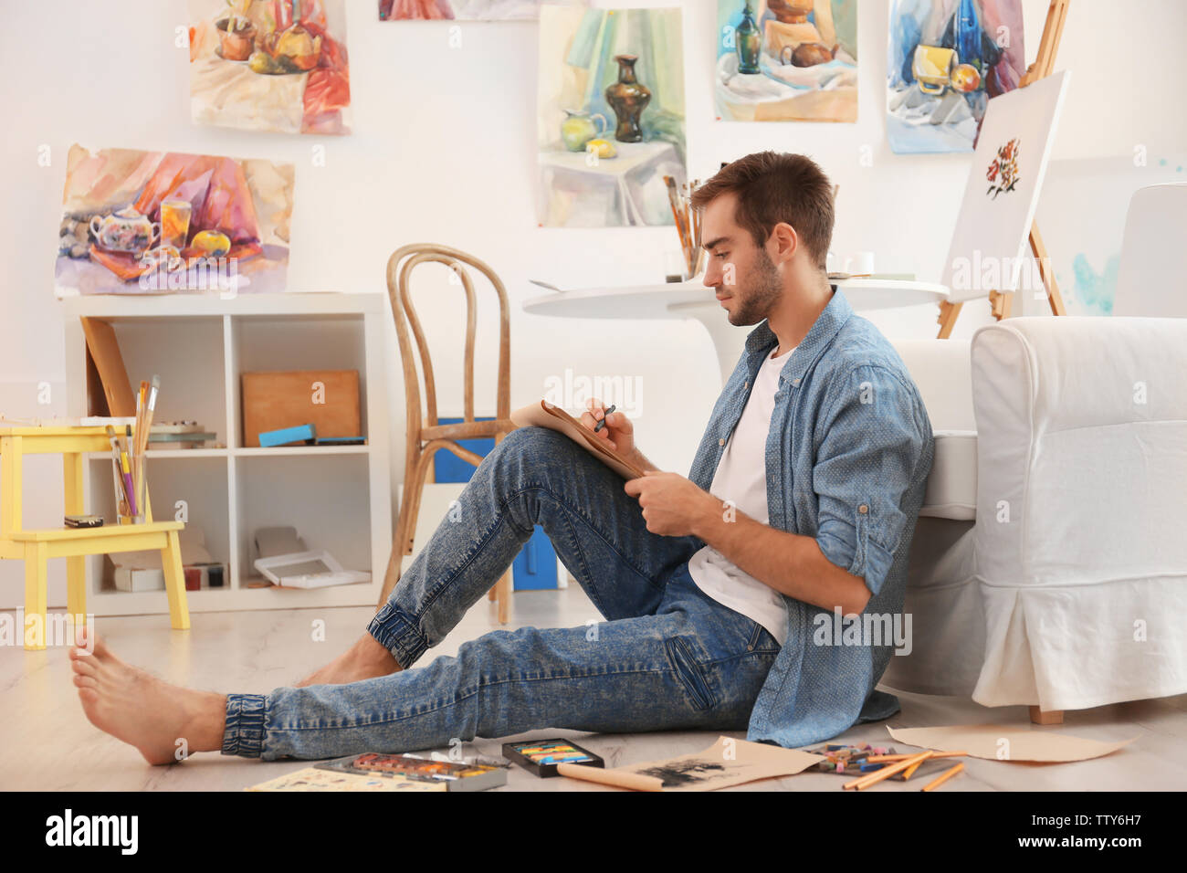 Young male artist drawing sketch in studio Stock Photo - Alamy