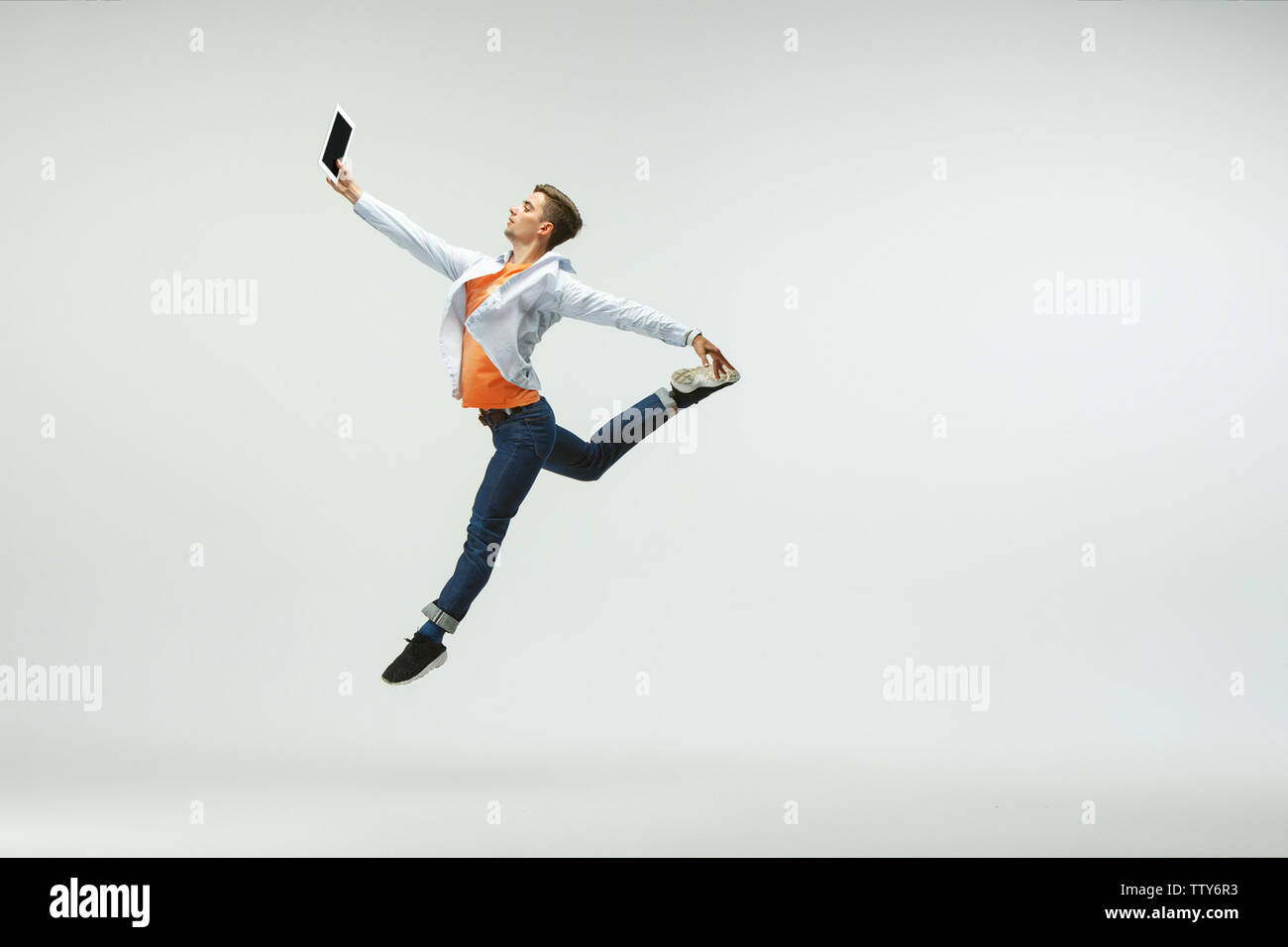 Happy young man working at office, jumping and dancing in casual ...