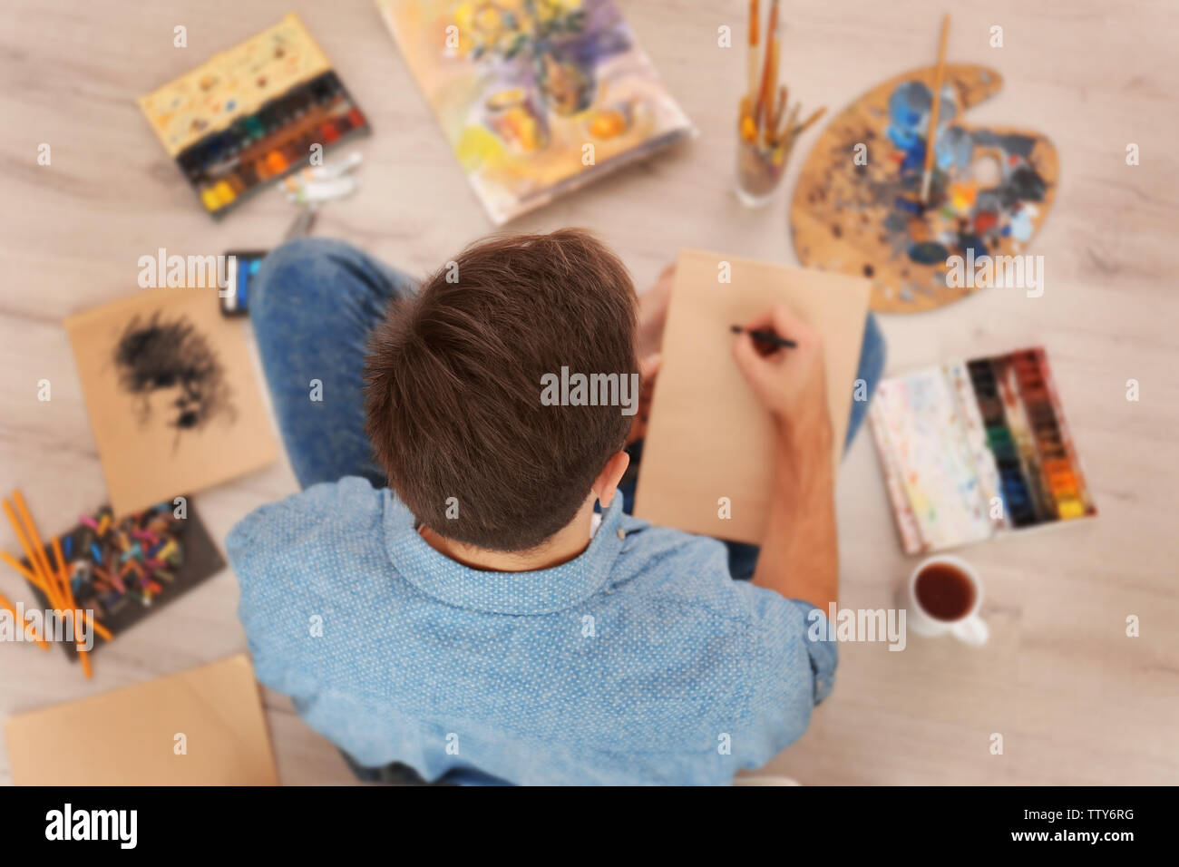 Young male artist drawing sketch in studio Stock Photo - Alamy