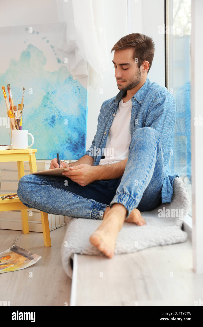 Young male artist drawing sketch in studio Stock Photo - Alamy