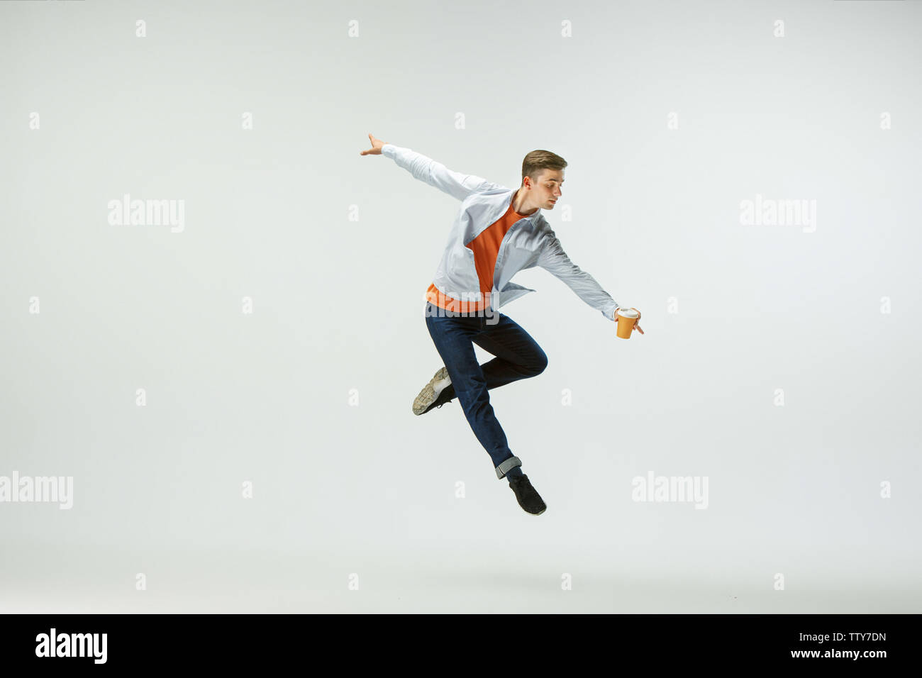 Happy young man working at office, jumping and dancing in casual ...
