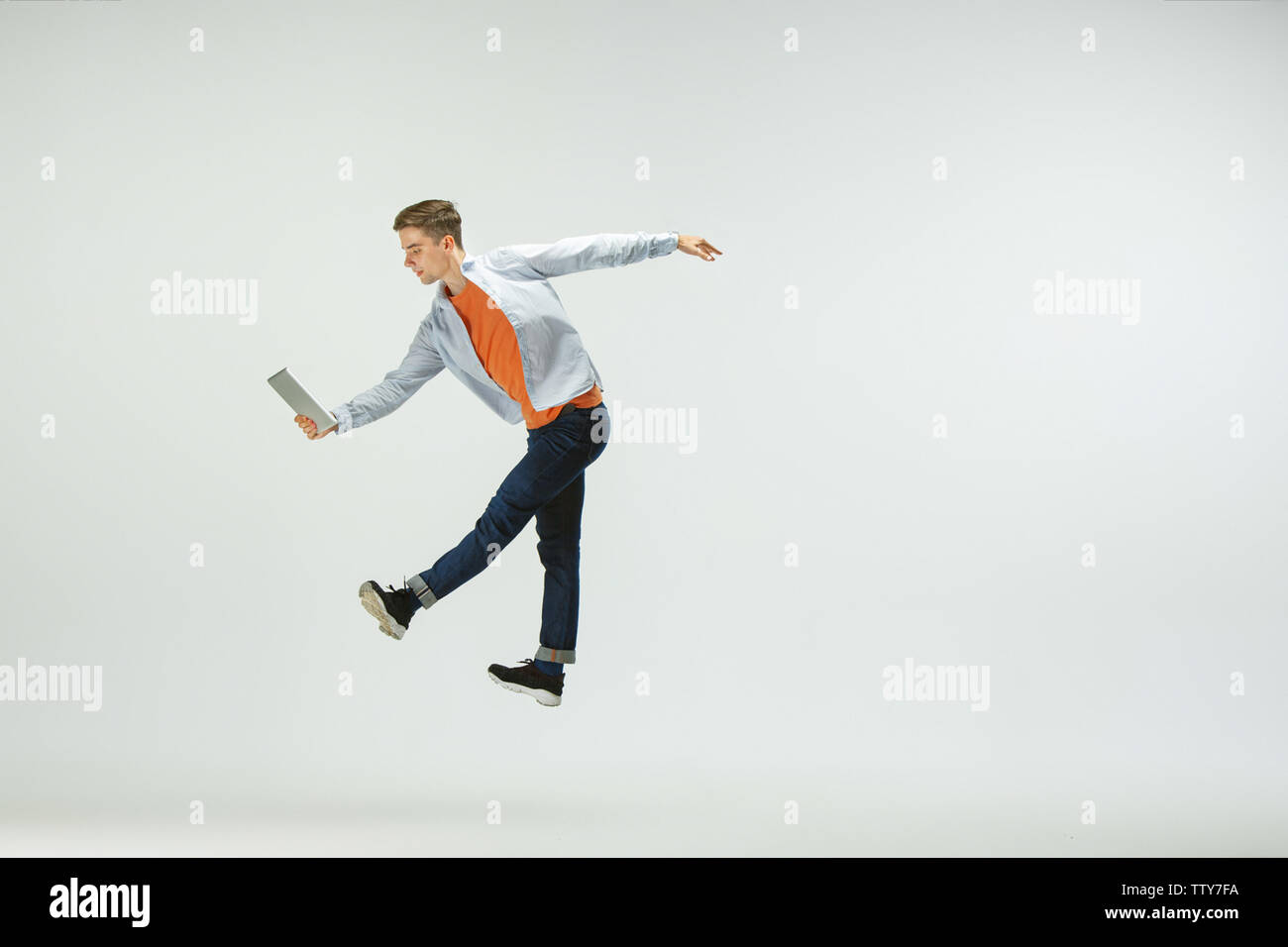 Happy young man working at office, jumping and dancing in casual ...