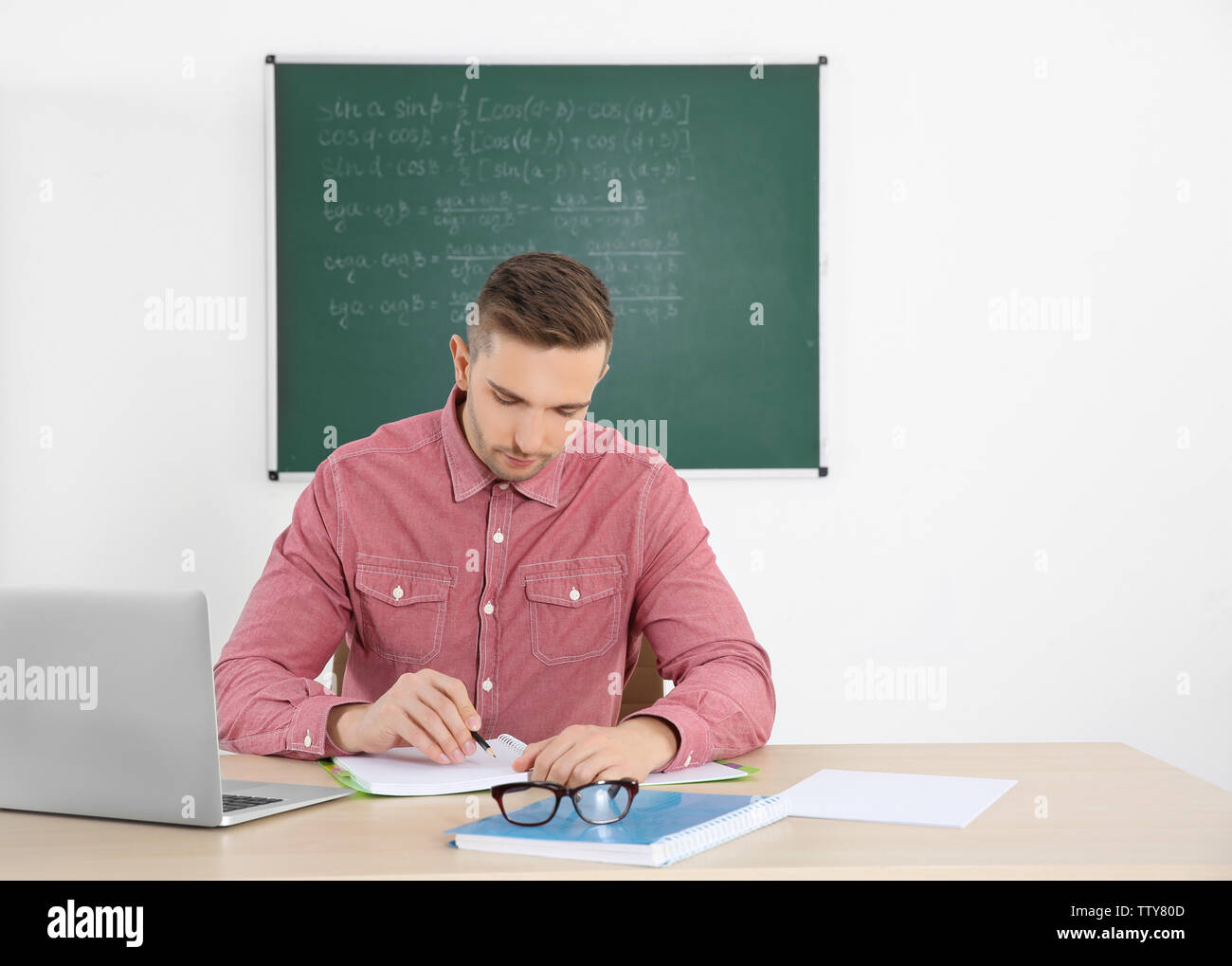 Young male teacher working in classroom Stock Photo - Alamy