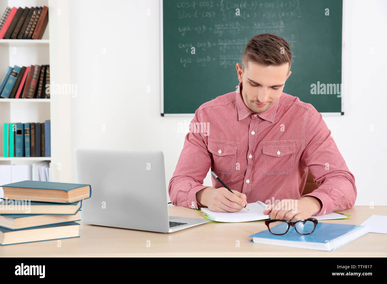 Young male teacher working in classroom Stock Photo - Alamy