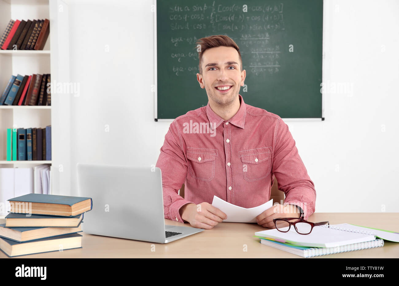 Young male teacher working in classroom Stock Photo - Alamy