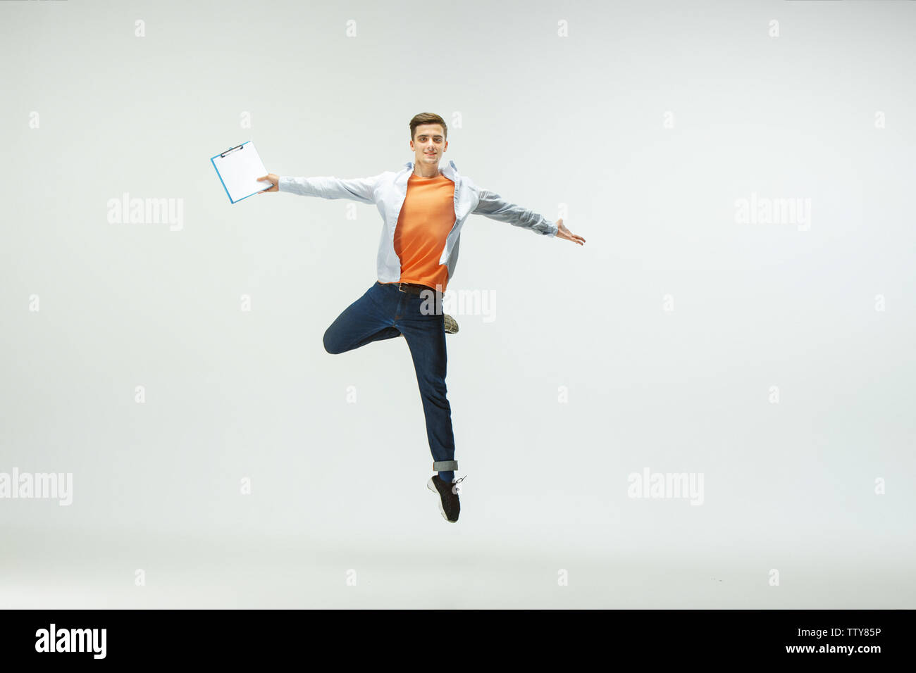 Happy young man working at office, jumping and dancing in casual ...