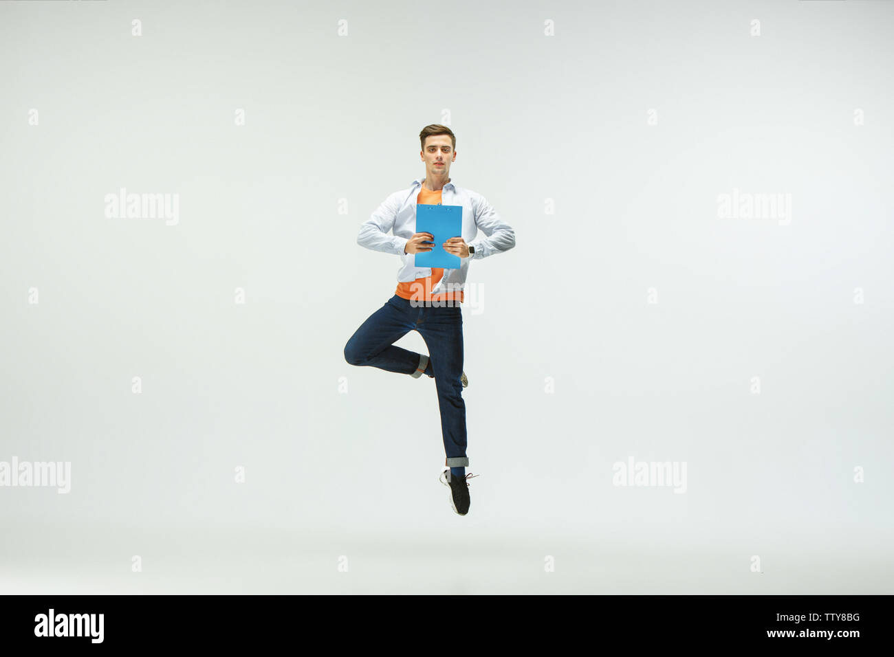 Happy young man working at office, jumping and dancing in casual ...