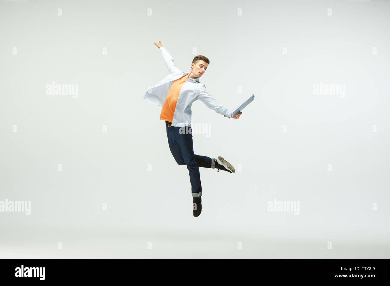 Happy young man working at office, jumping and dancing in casual ...