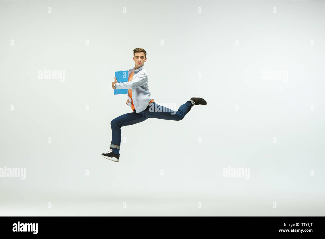Happy young man working at office, jumping and dancing in casual ...