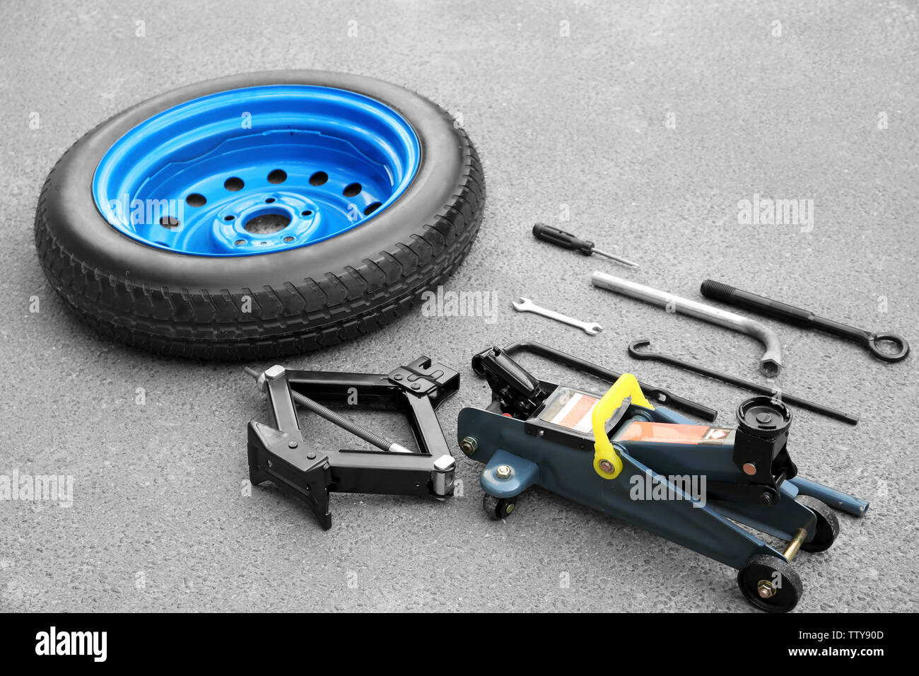 Car wheel with tools on asphalt background Stock Photo - Alamy