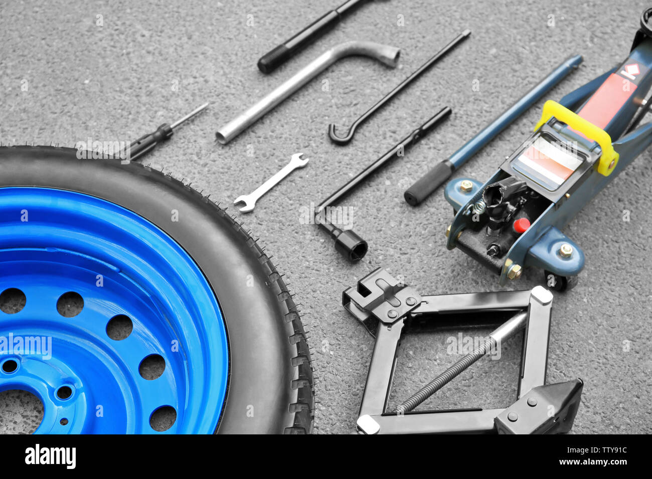 Car wheel with tools on asphalt background Stock Photo - Alamy