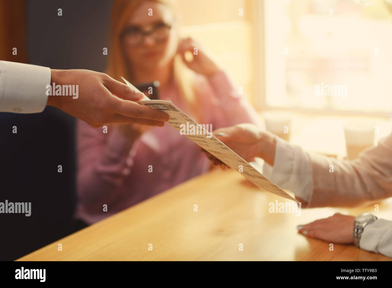 Hand of waiter showing menu to young woman, close up view Stock Photo ...