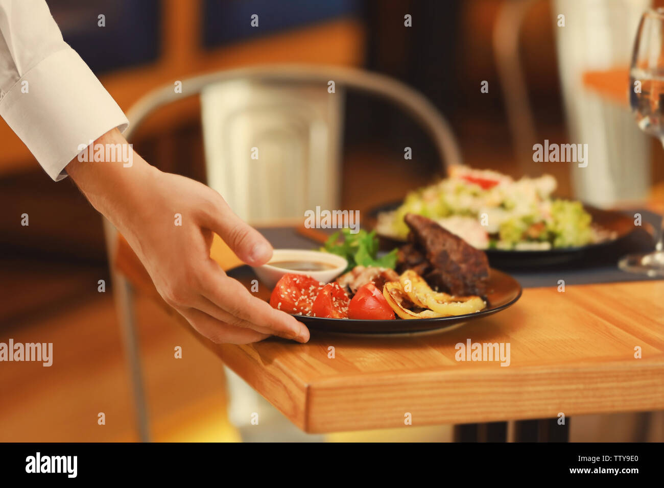 Waiter serving meals in restaurant, close up Stock Photo - Alamy
