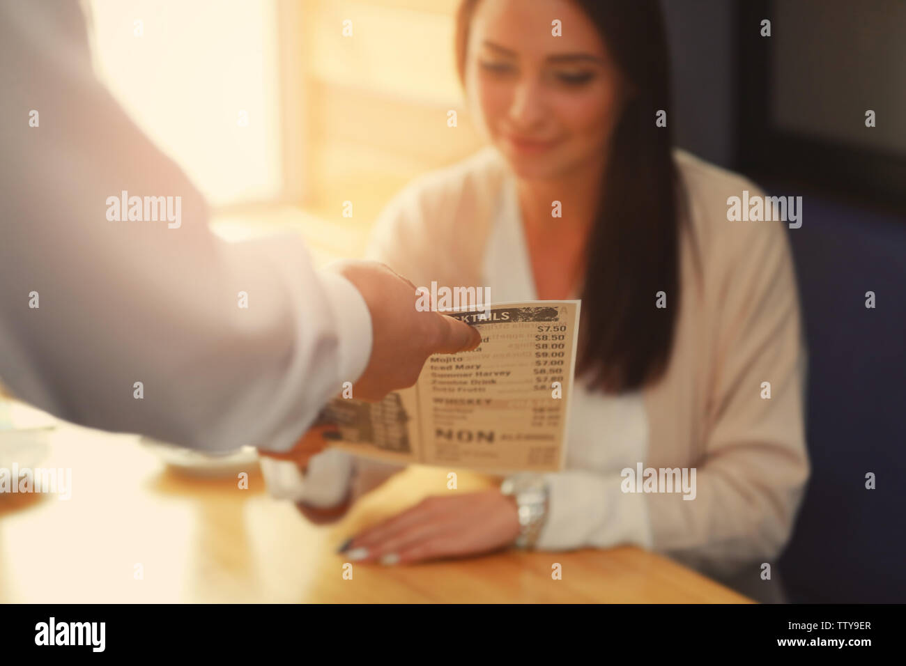 Hand of waiter showing menu to young woman, close up view Stock Photo ...