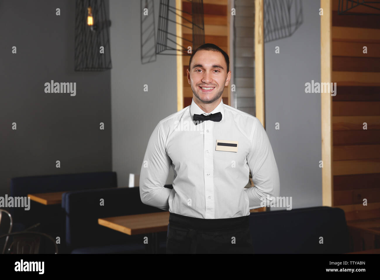 Young handsome waiter standing in the restaurant Stock Photo - Alamy