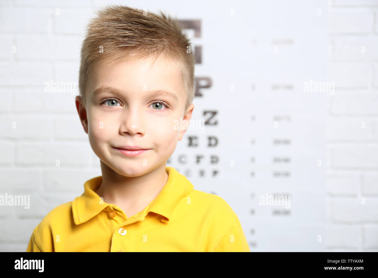 Little boy on ophthalmic test chart background Stock Photo - Alamy