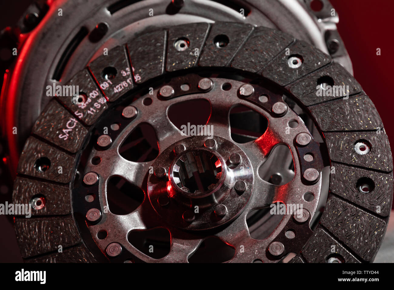 Shot of modern new spare parts for car in red artificial lighting made ...