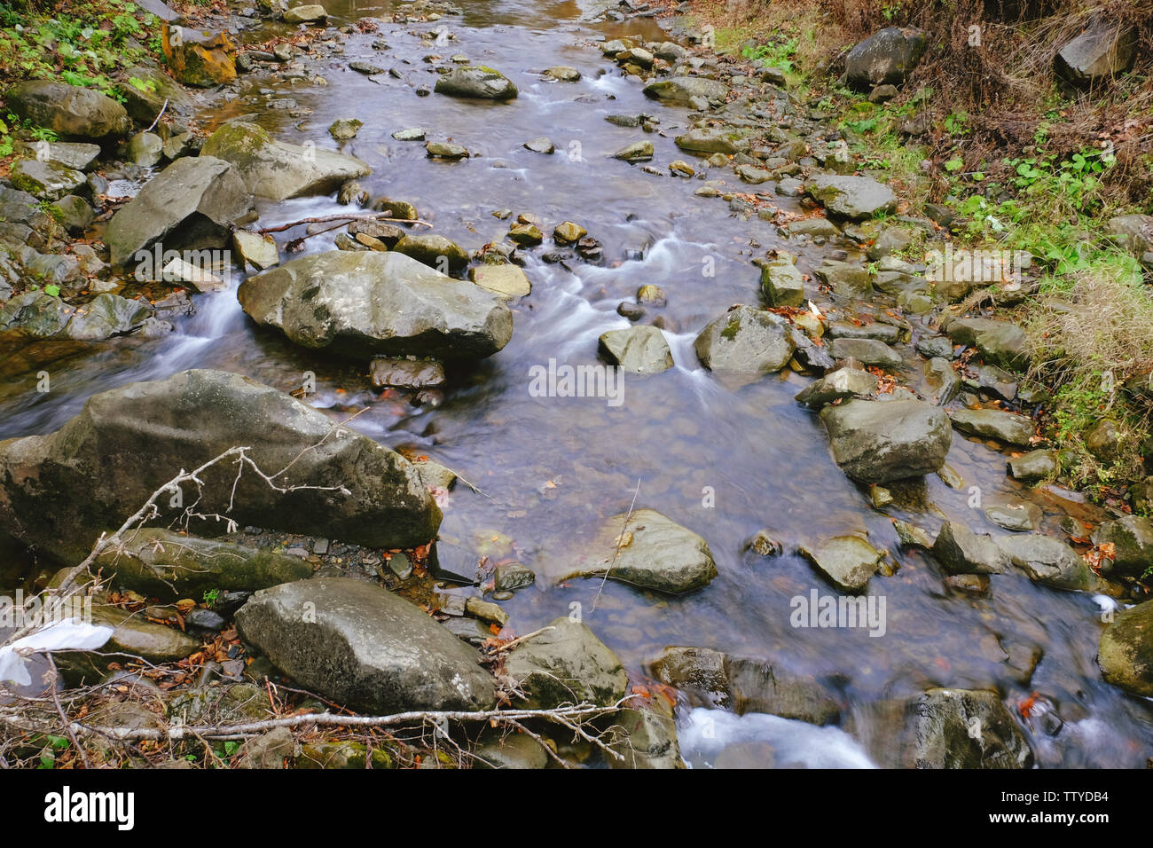 Stream flowing through rocky path in mountains Stock Photo - Alamy