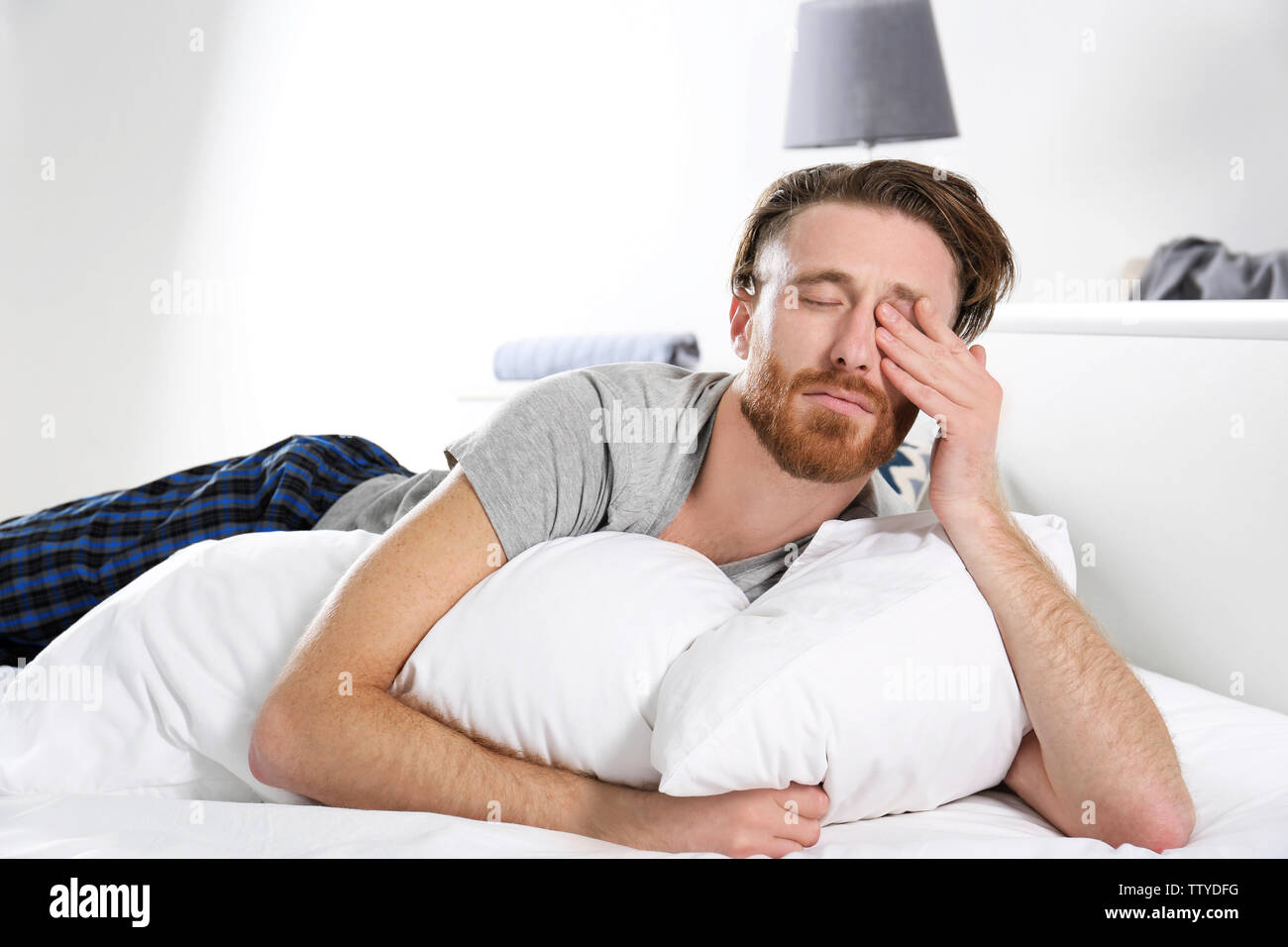 Young man waking up in bed at home Stock Photo - Alamy