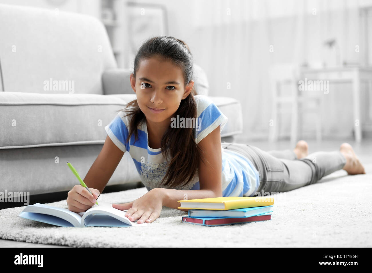 Cute girl doing lessons at home Stock Photo - Alamy