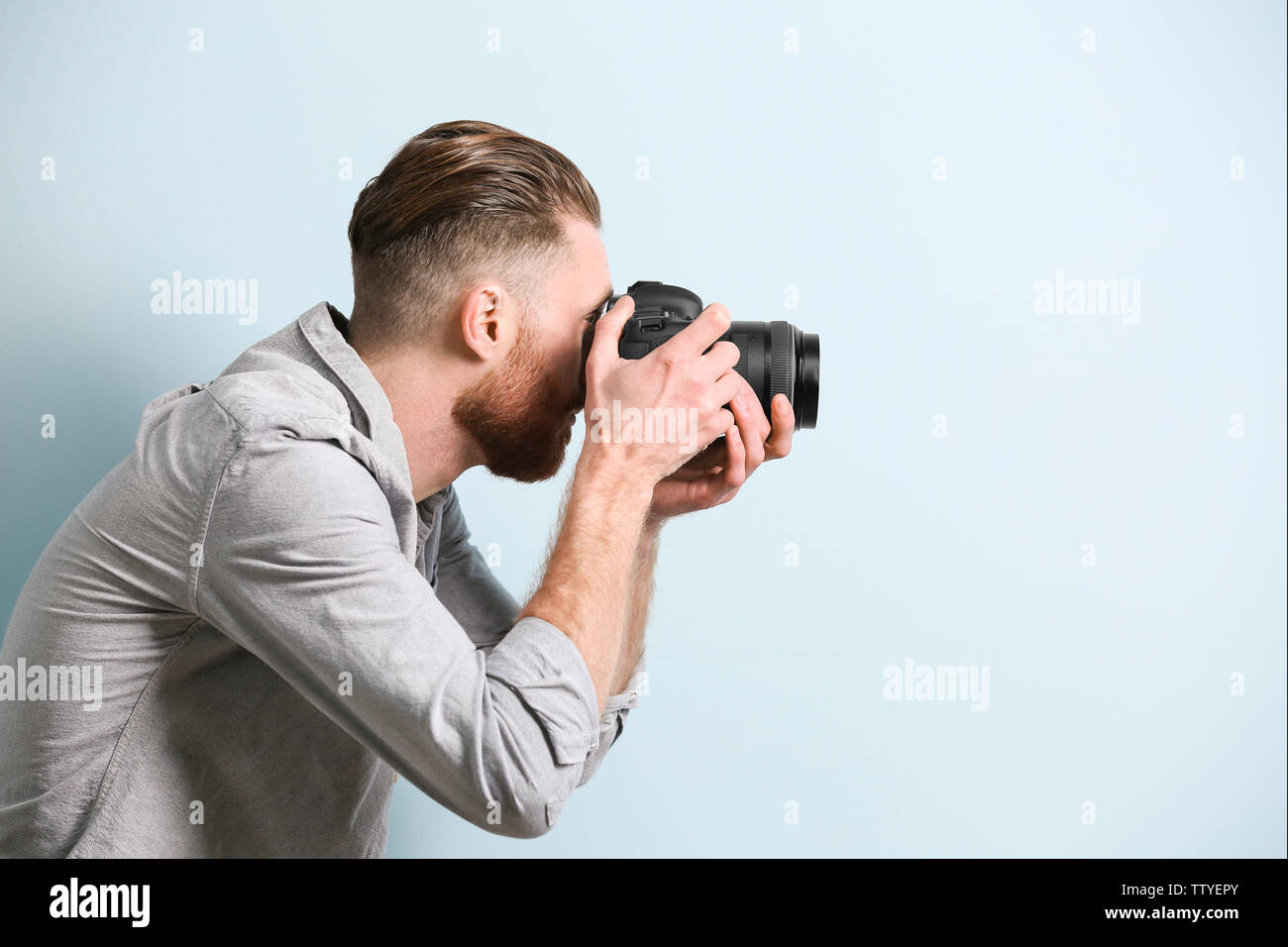 Handsome photographer on color background Stock Photo - Alamy
