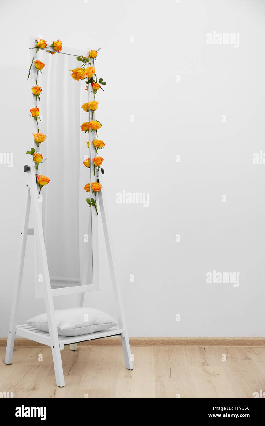 Mirror decorated with beautiful flowers near white wall Stock Photo - Alamy