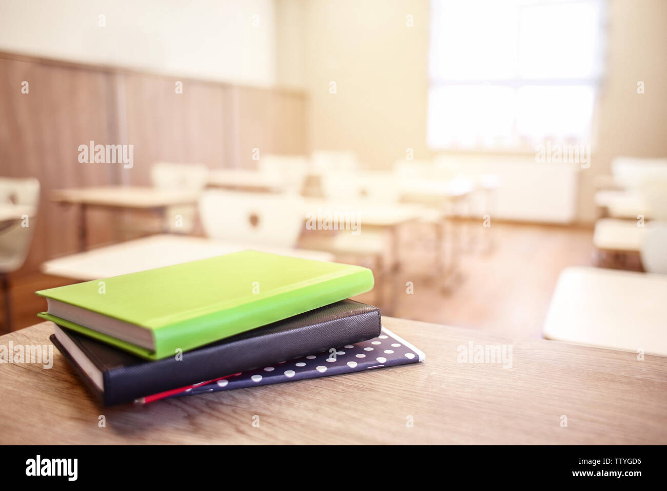 School teacher's desk with stack of books Stock Photo - Alamy
