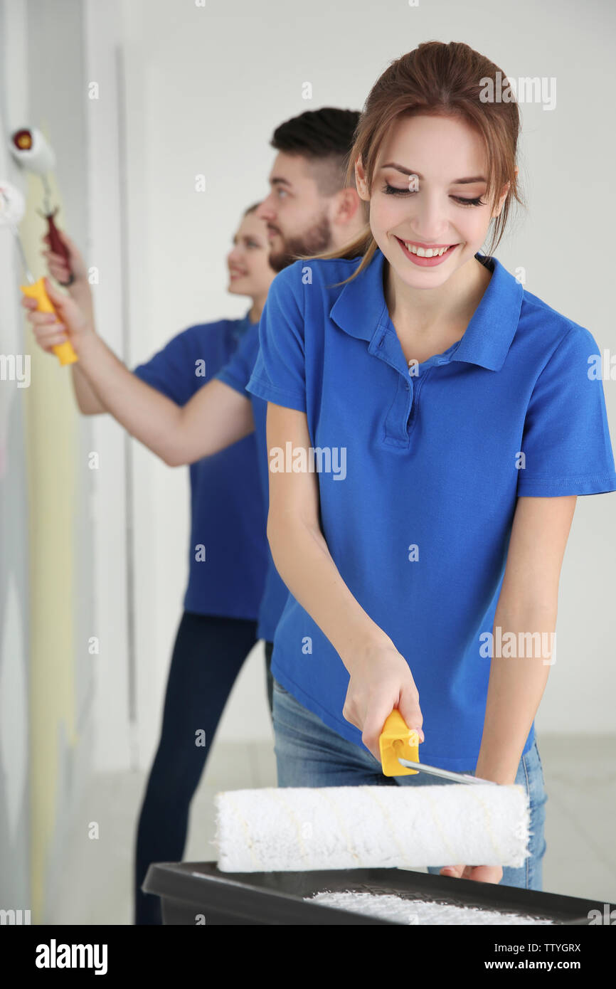 Young decorators painting wall in room Stock Photo - Alamy