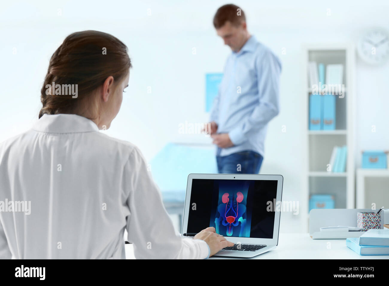 Medical concept. Doctor looking at laptop screen with urology system ...